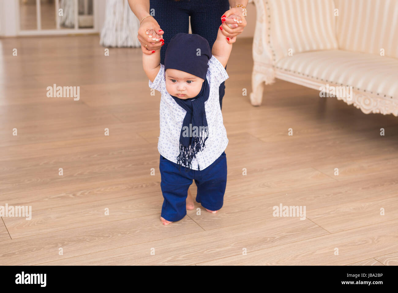 baby taking first steps with mother help Stock Photo - Alamy