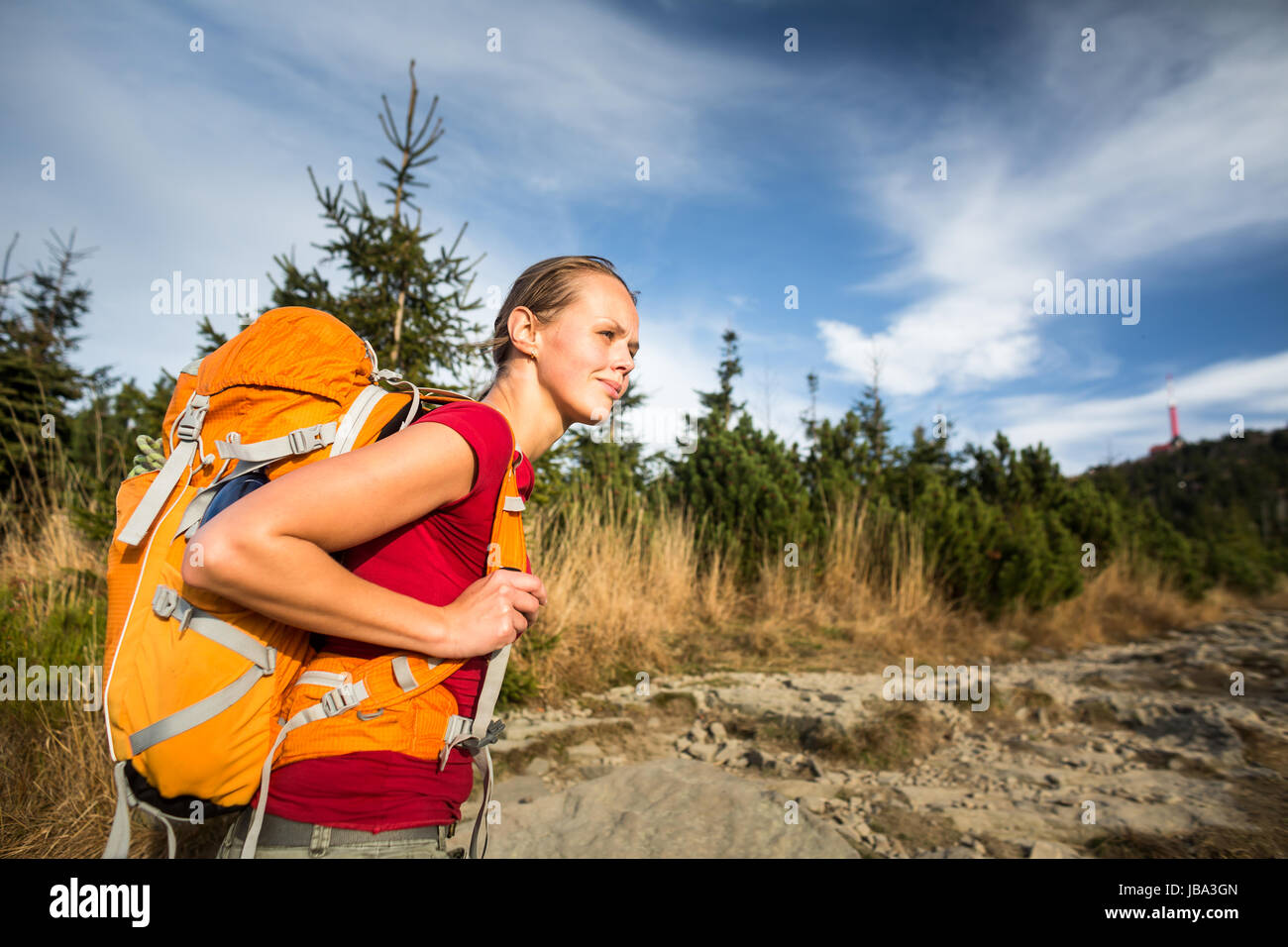 Pretty, female hiker going uphill in warm evening light Stock Photo - Alamy