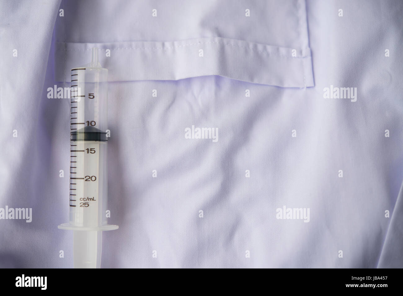 Injection needle on white lab coat background Stock Photo - Alamy