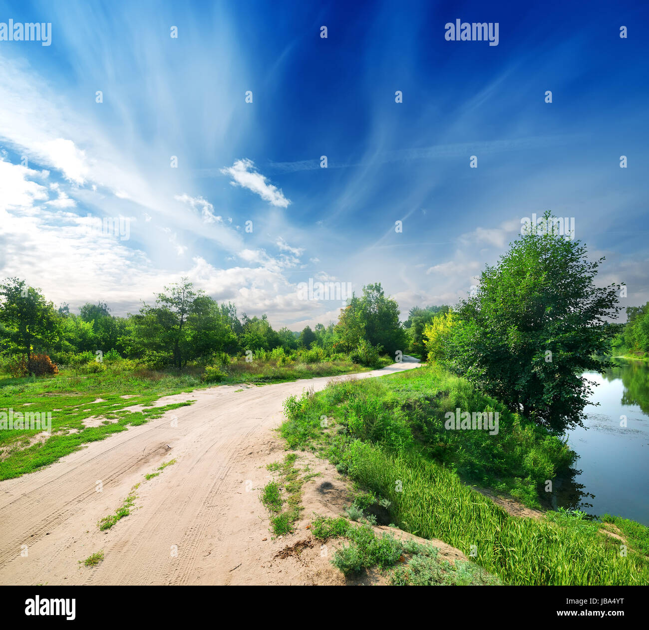 Country road, calm river and cloudy sky Stock Photo - Alamy