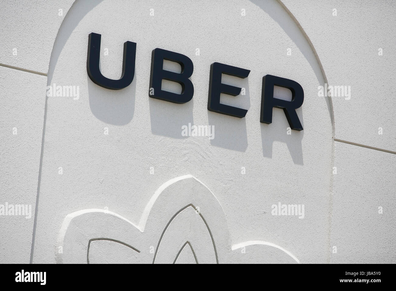 A logo sign outside of a Uber Technologies regional office in Houston ...