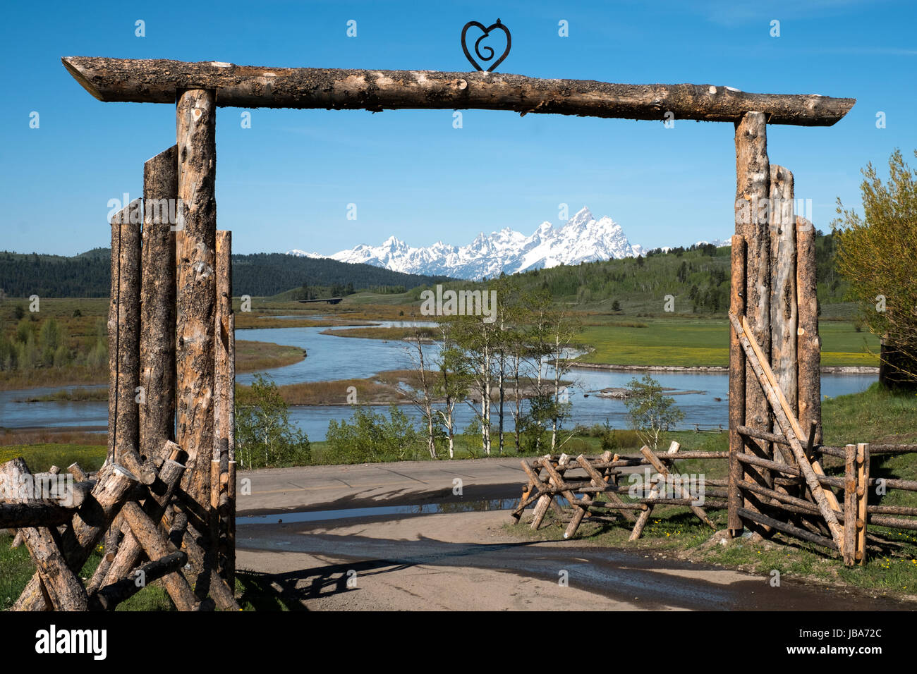 The snow capped Teton mountain range framed by the arch of the Heart ...