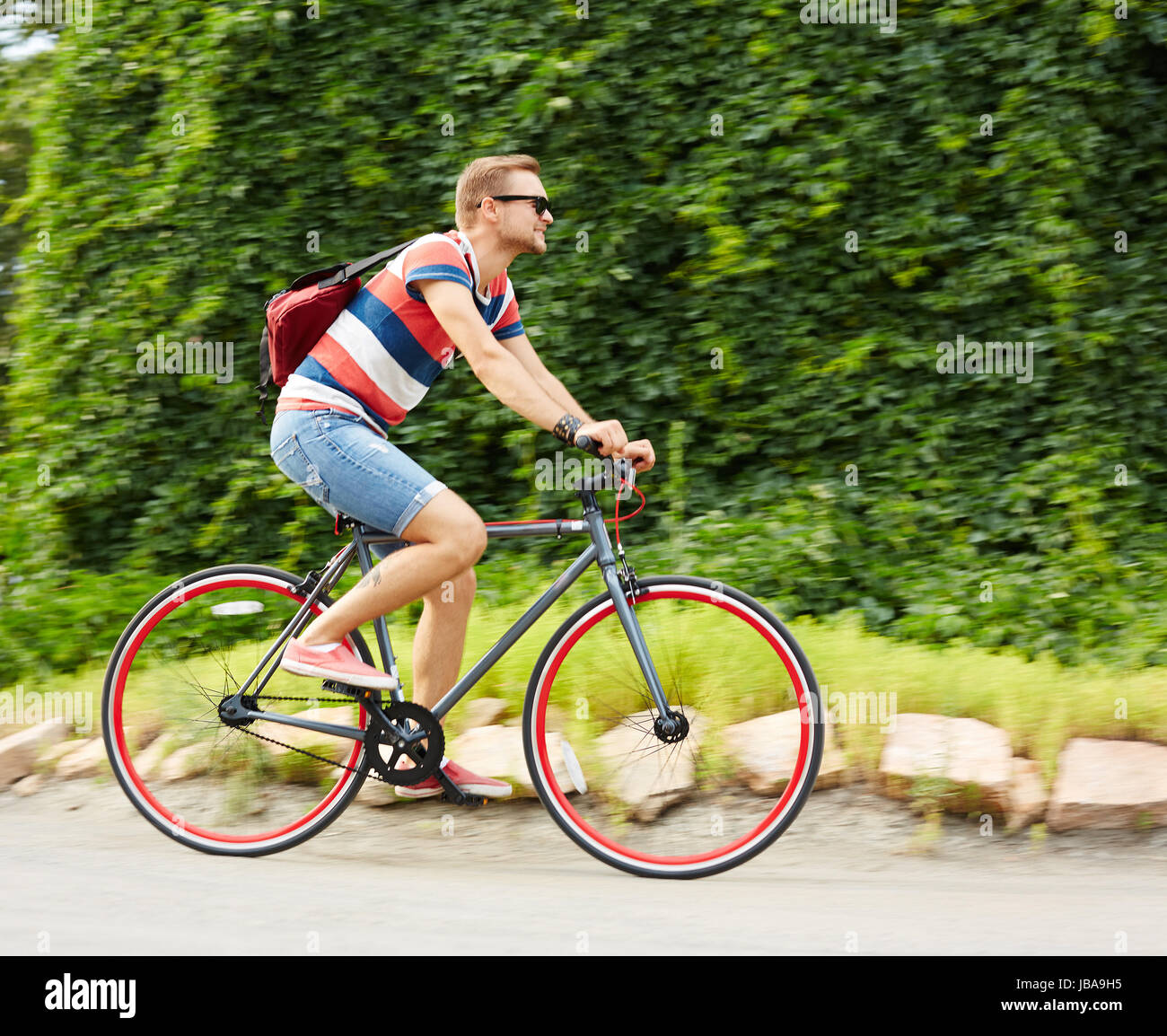 Portrait of handsome guy riding bicycle in the park Stock Photo - Alamy
