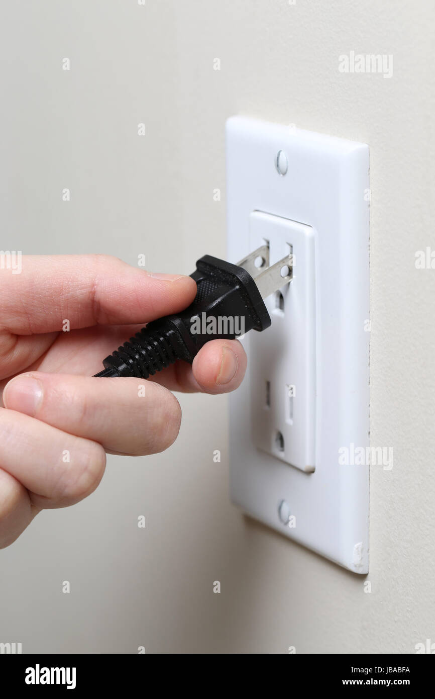 Inserting electrical power cord socket hi-res stock photography and ...