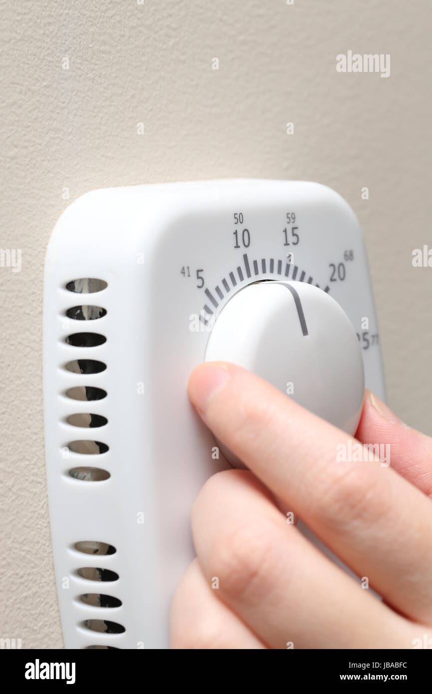 Woman hand setting a thermostat Stock Photo - Alamy