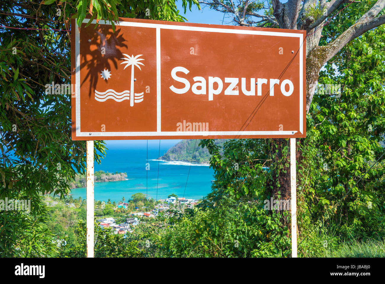 Sign at the entrance to Sapzurro with the town and bay visible below ...