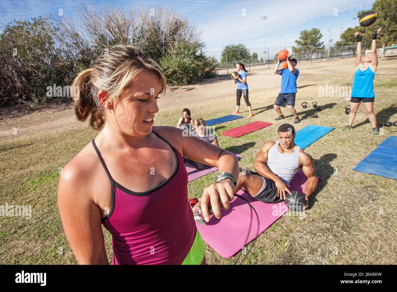 Boot camp fitness trainer checking group with stopwatch Stock Photo - Alamy