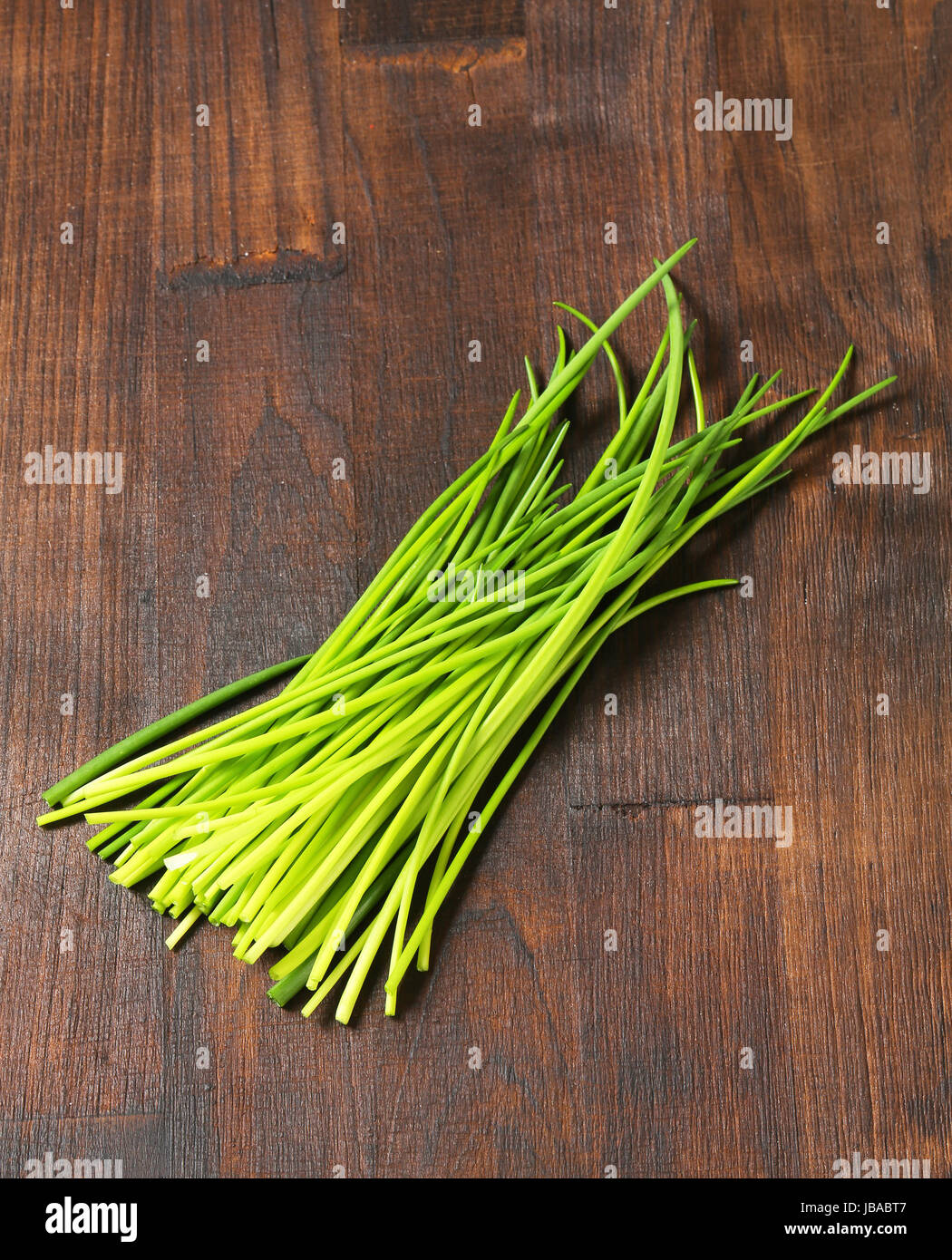 Fresh chives leaves on wooden background Stock Photo - Alamy