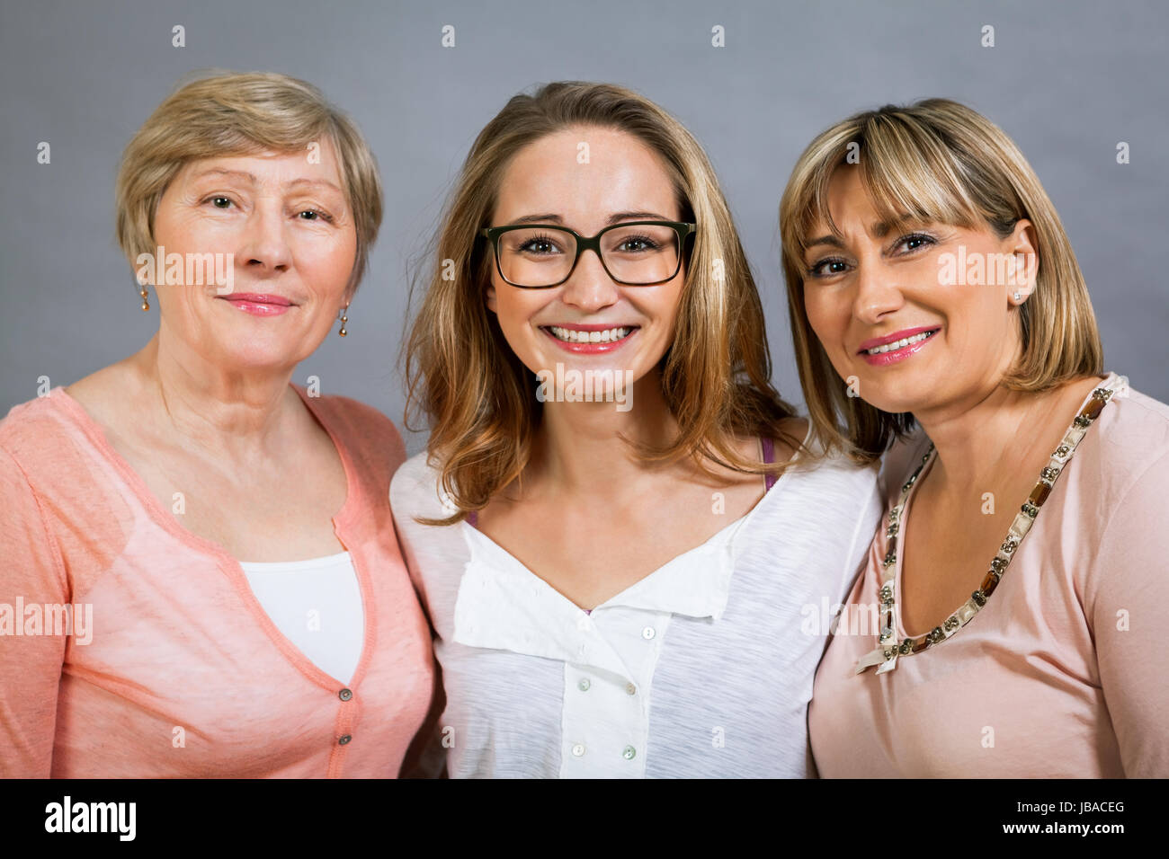 drei generationen großmutter mutter und tochter im portrait vor grauem ...
