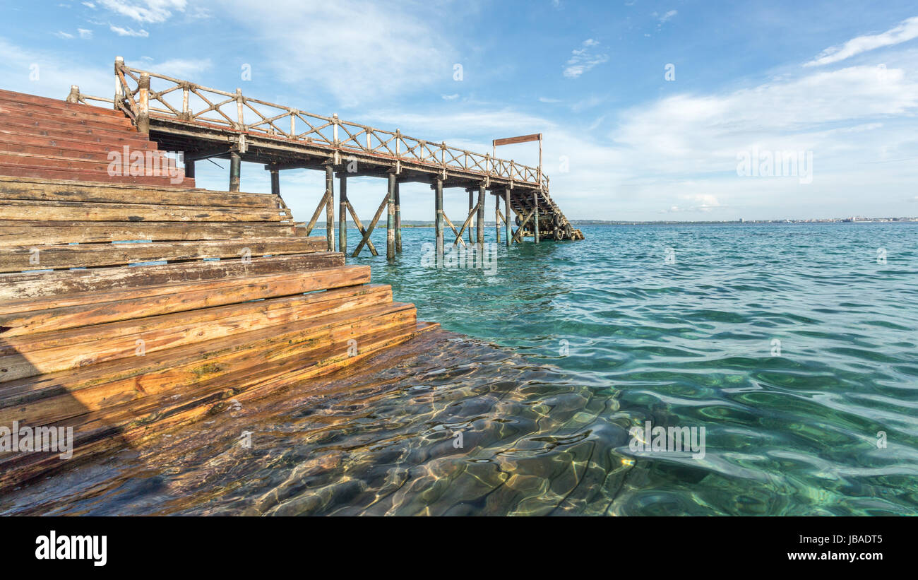 An old wooden bridge built on the shore of Prison Island in Zanzibar ...