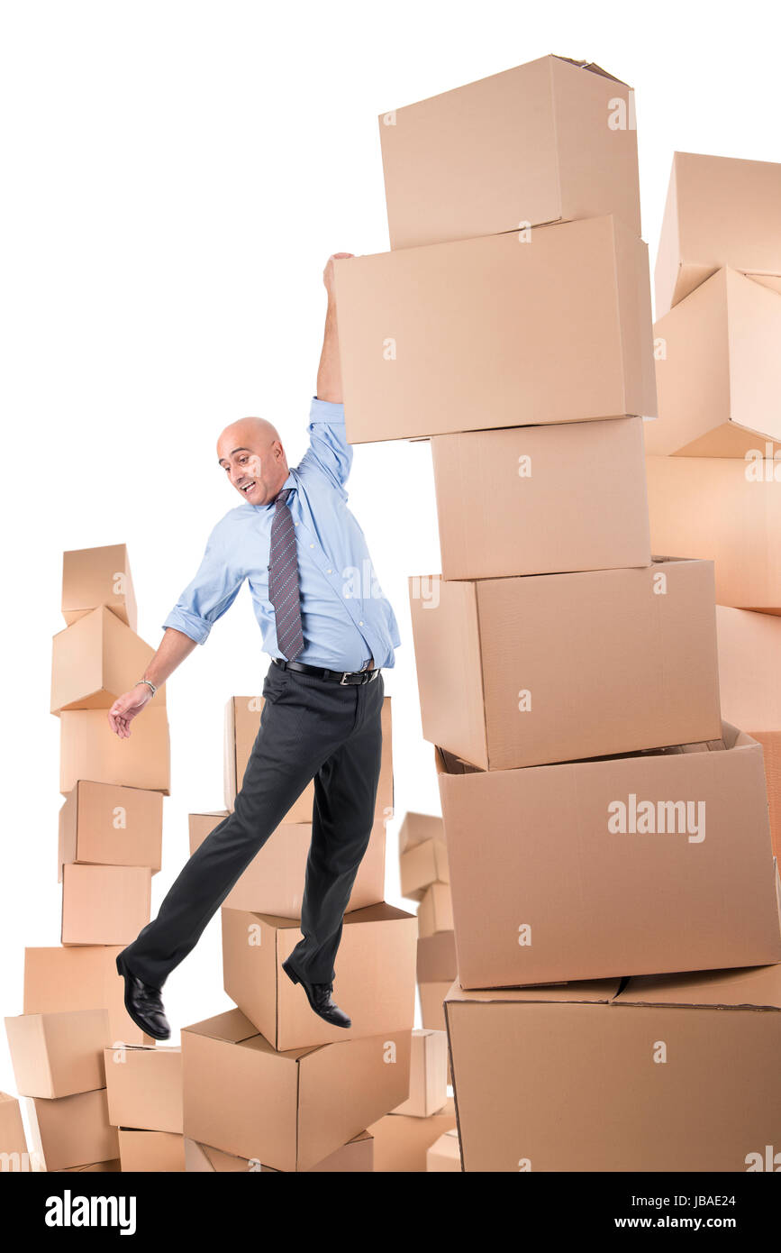 Businessman hanging over a cardboard box cliff Stock Photo - Alamy