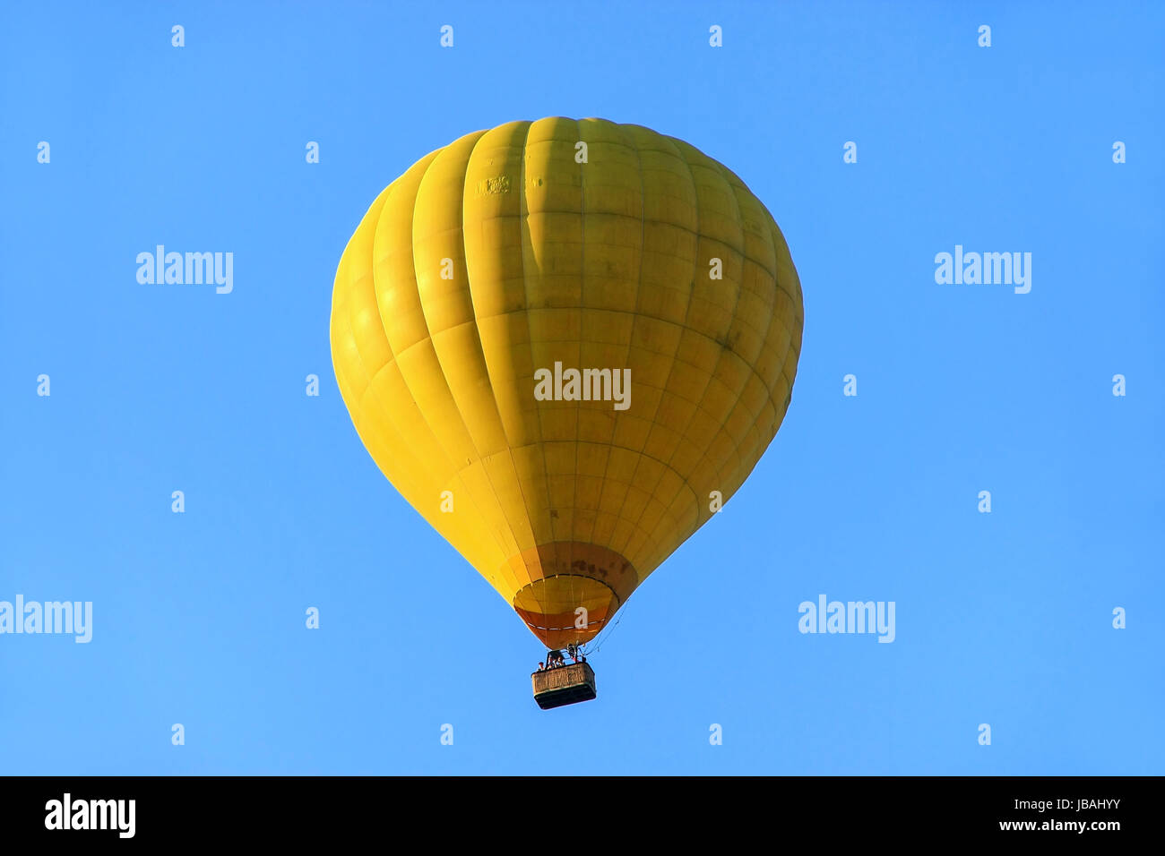 Yellow hot air balloon in blue sky Stock Photo - Alamy