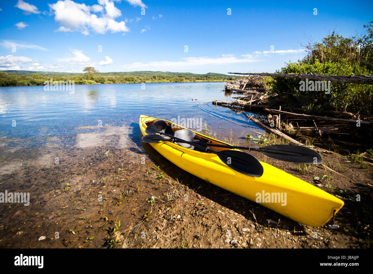 Yellow Kayak Ready to be Used on the Cost of a River Stock Photo - Alamy