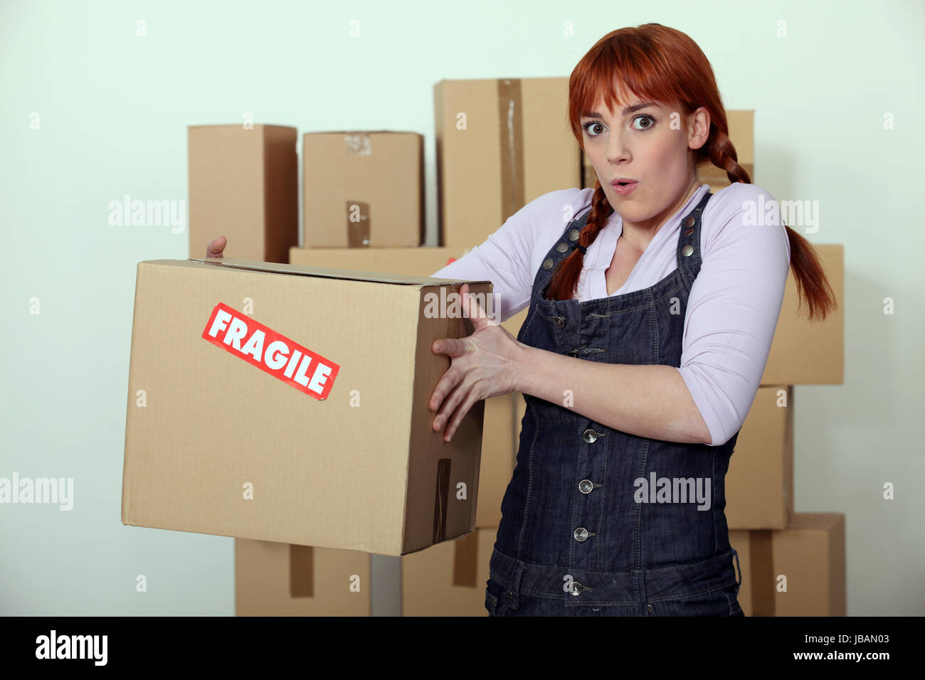 Woman carrying fragile box Stock Photo - Alamy