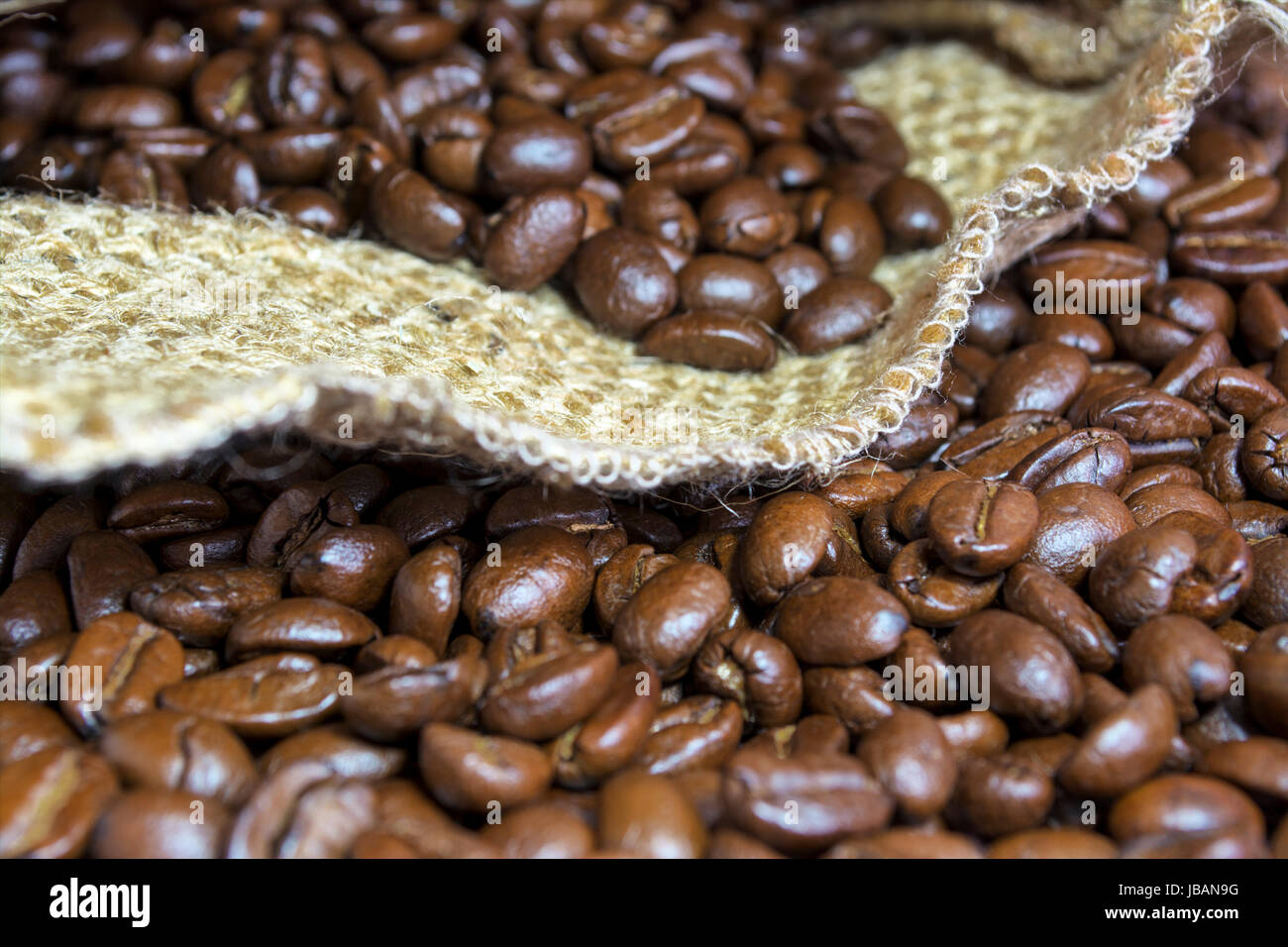 Coffee beans inside his jute bag with side lighting Stock Photo - Alamy