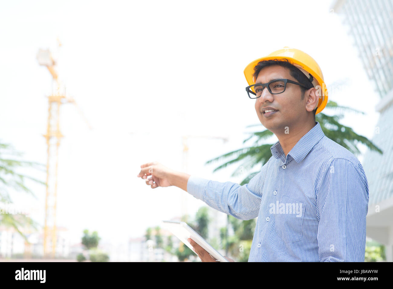 Portrait of a smiling Indian male contractor engineer with hard hat ...