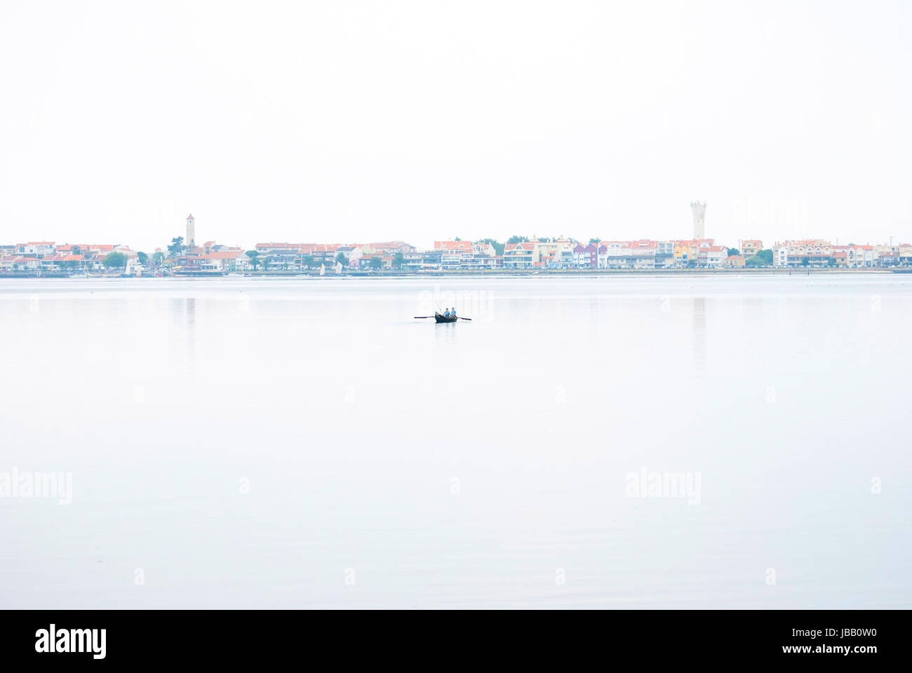 Lonely fishing boat with cityscape behind Stock Photo - Alamy