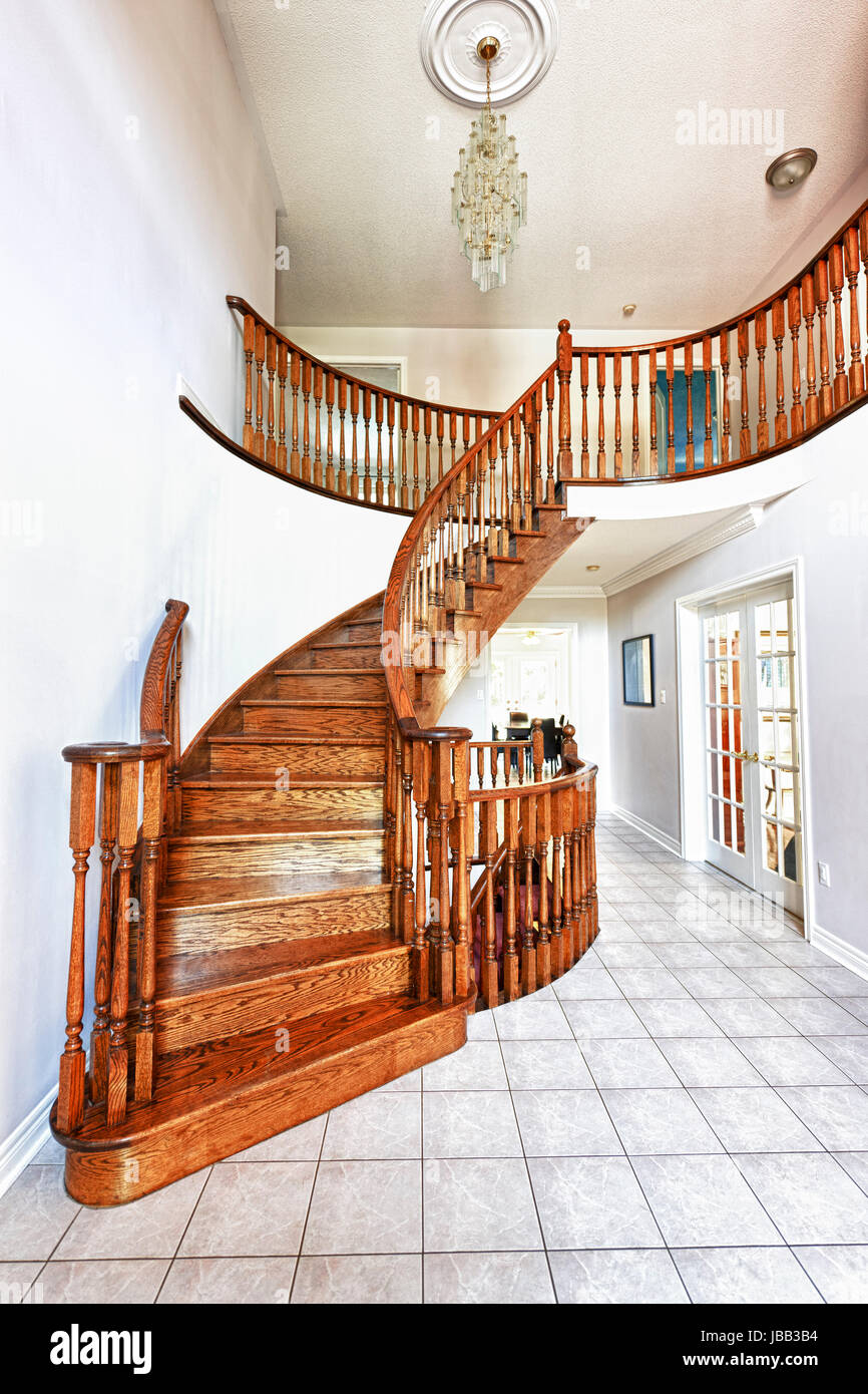 Curved oak staircase in luxury home entrance hall Stock Photo - Alamy