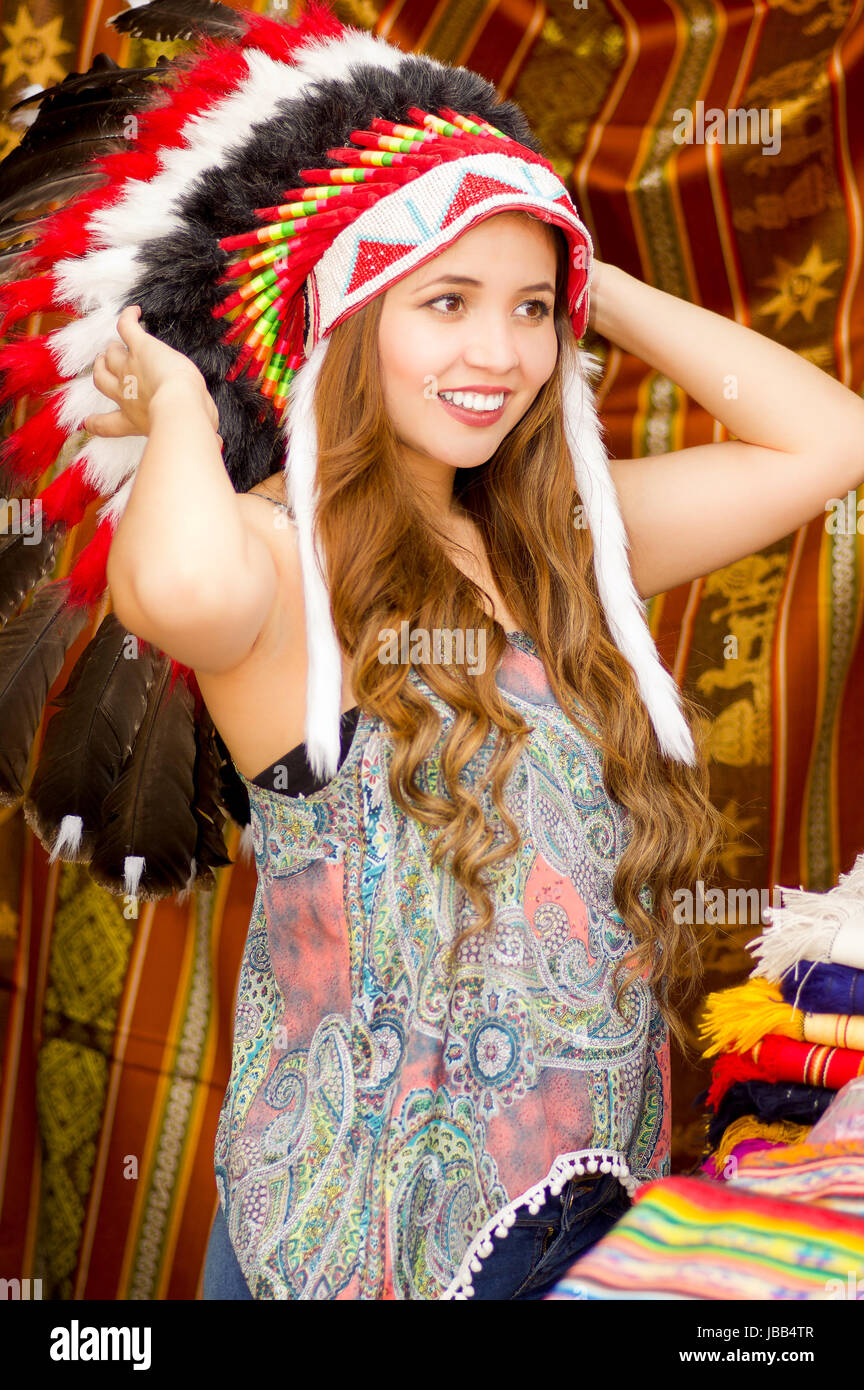 A beautiful young woman wearing Native American hat feather. with ...