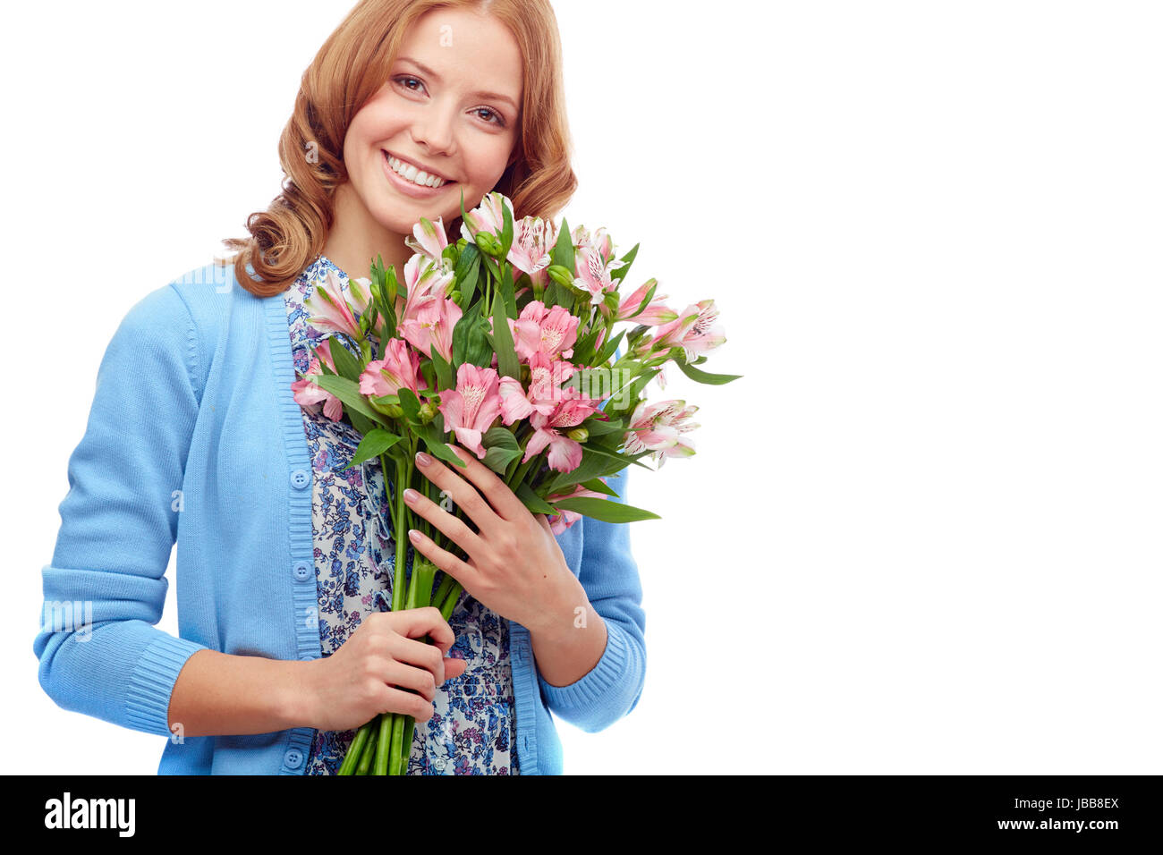 Portrait of smiling female with bunch of pink lilies looking at camera ...