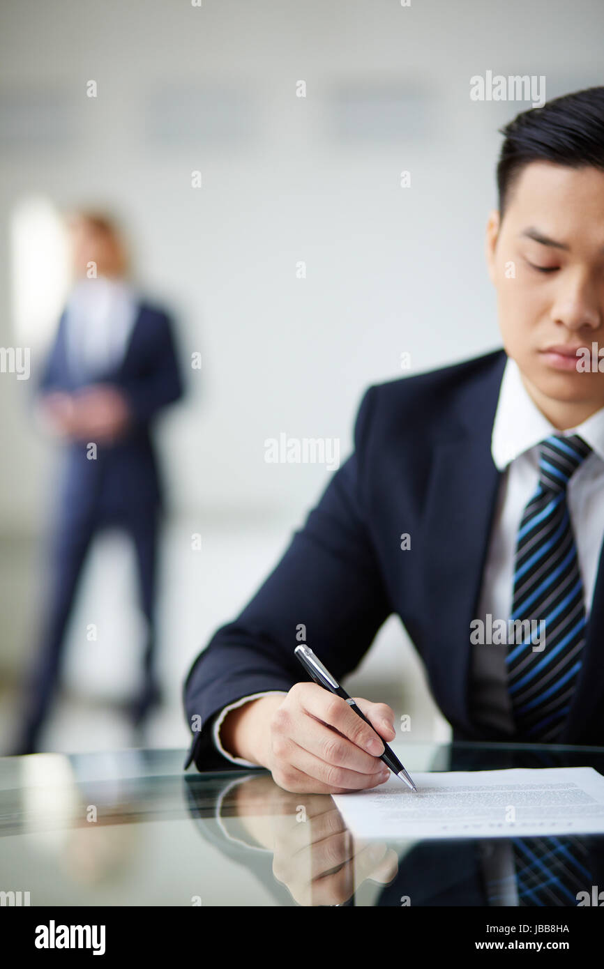 Serious businessman reading paper in office Stock Photo - Alamy