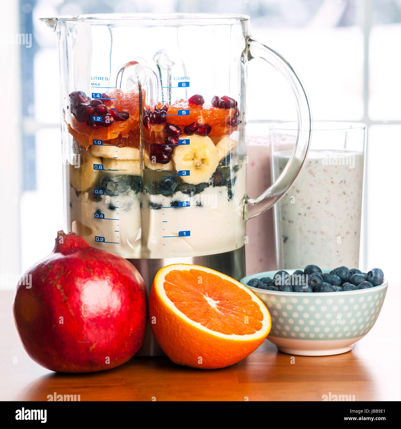 Prepared smoothies and healthy smoothie ingredients in blender with ...