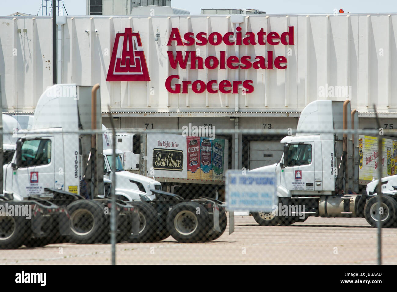 A logo sign outside of a facility occupied by Associated Wholesale ...