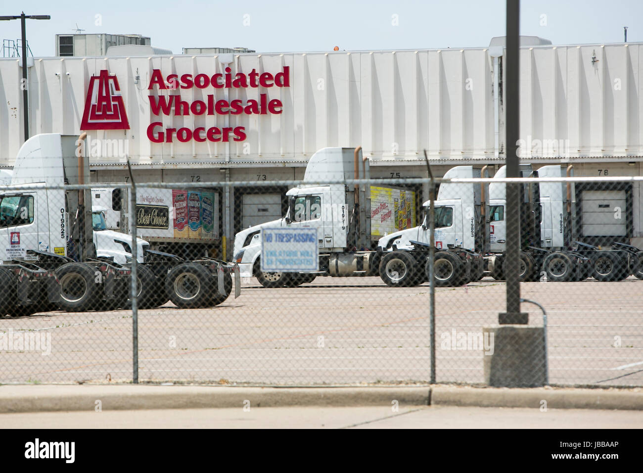 A logo sign outside of a facility occupied by Associated Wholesale ...