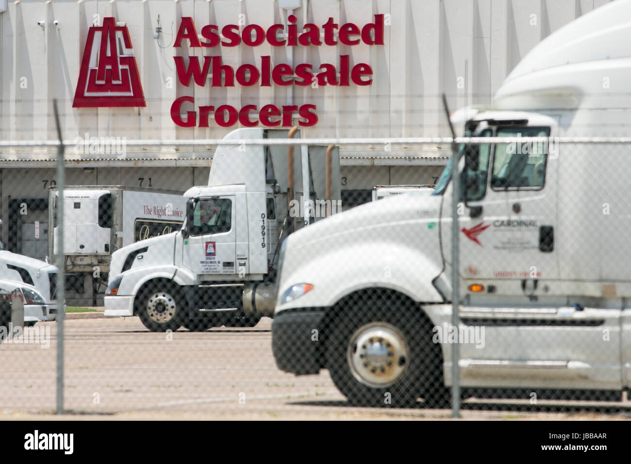 A logo sign outside of a facility occupied by Associated Wholesale ...
