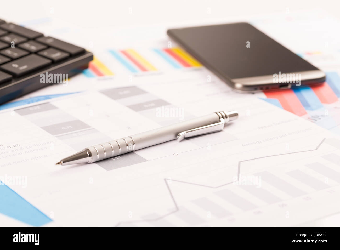 Financial printed paper charts, graphs on desk with pen, mobile ...