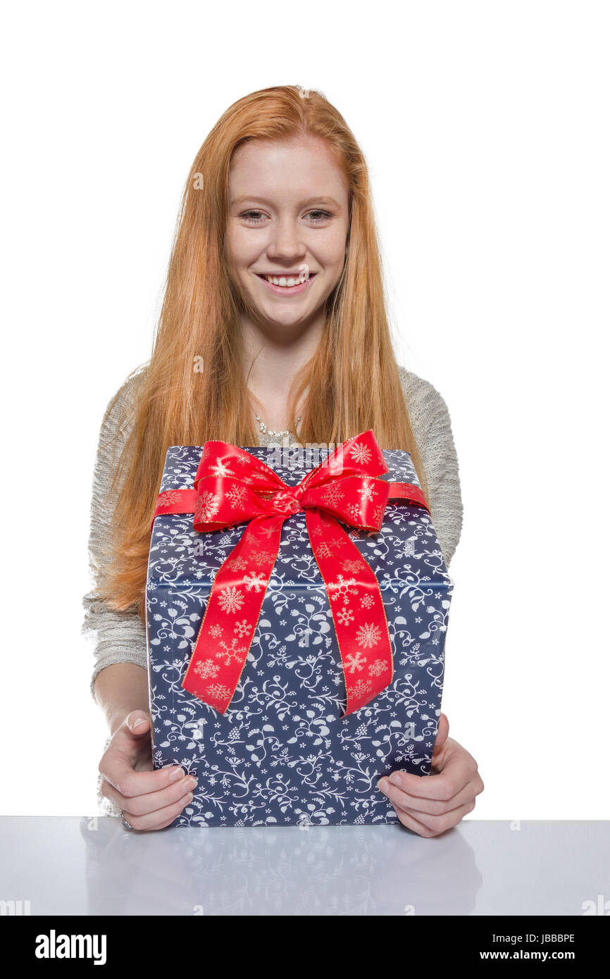 Young well dressed red haired Girl presents present with a big smile ...