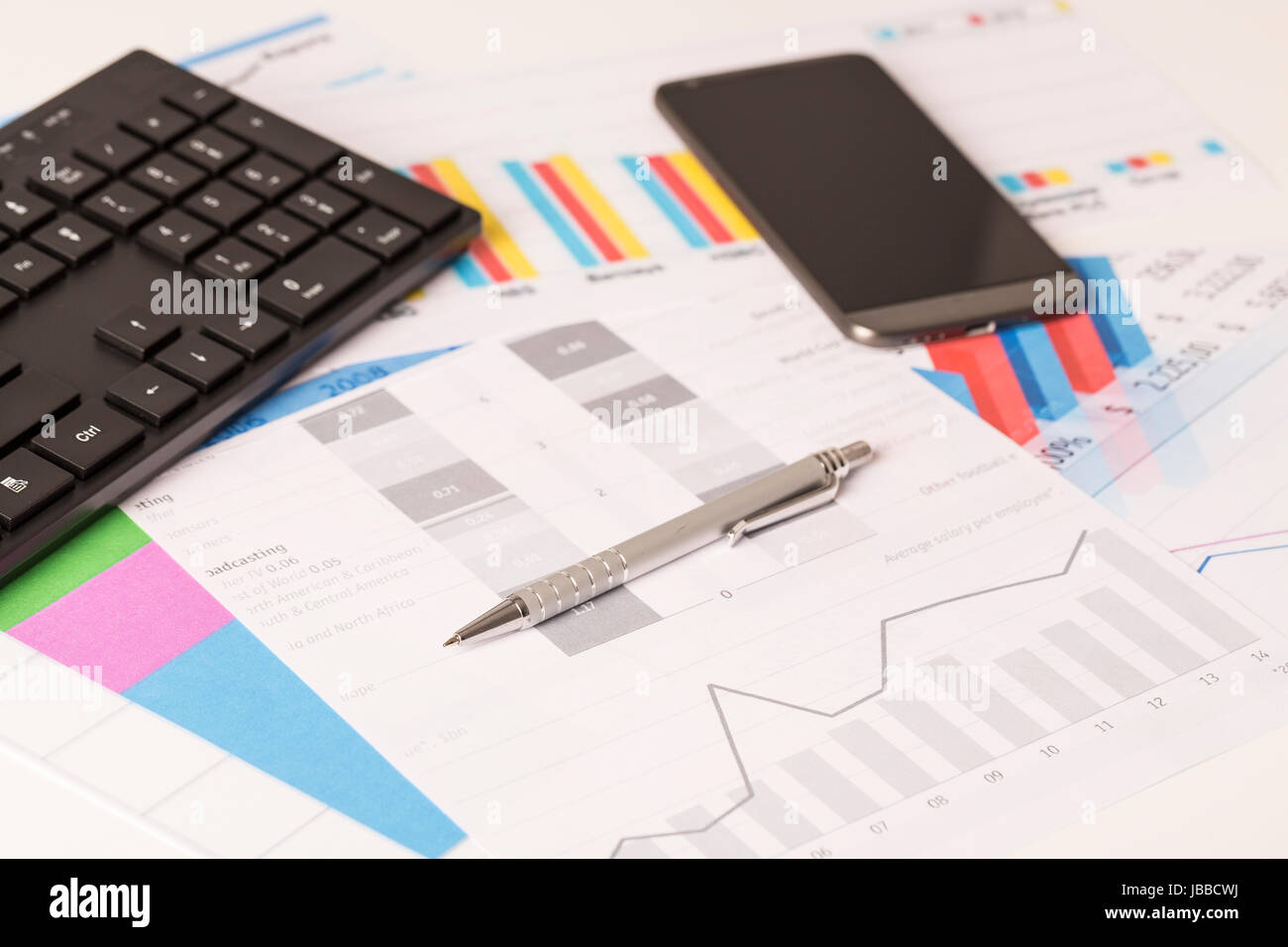 Financial printed paper charts, graphs on desk with pen, mobile ...