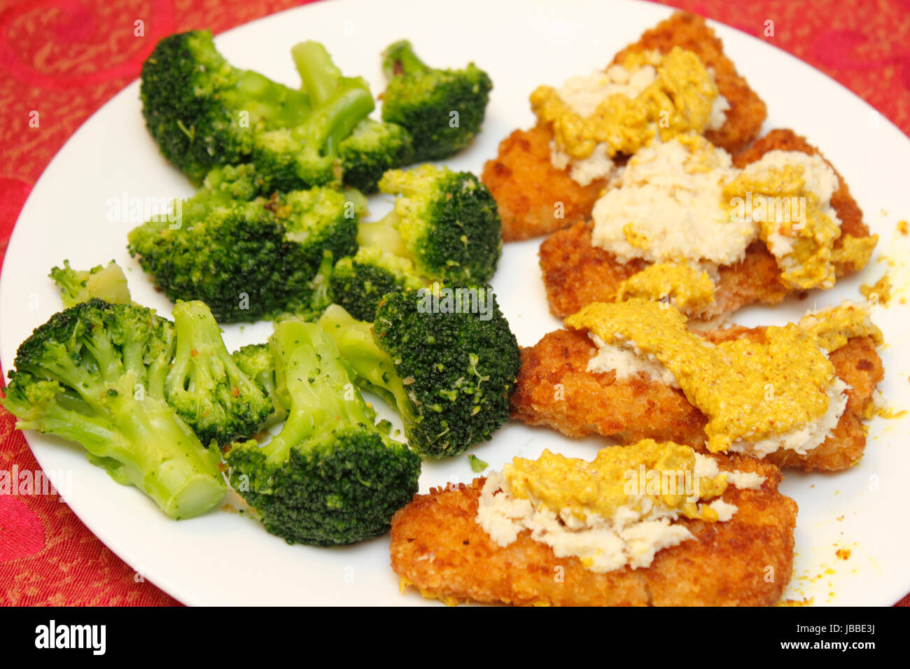Prepared lunch of buttered organic broccoli and cooked breaded pollock ...
