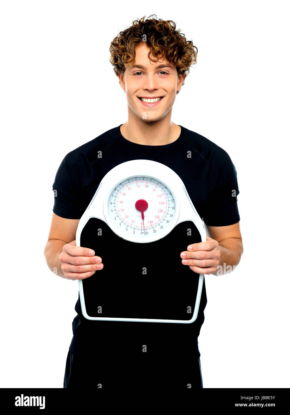 Attractive athlete showing weighing scale against white background ...