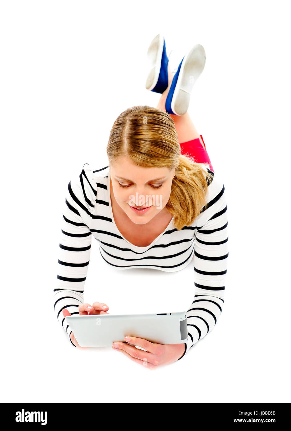 Woman using tablet computer. Lying on floor, white background Stock ...