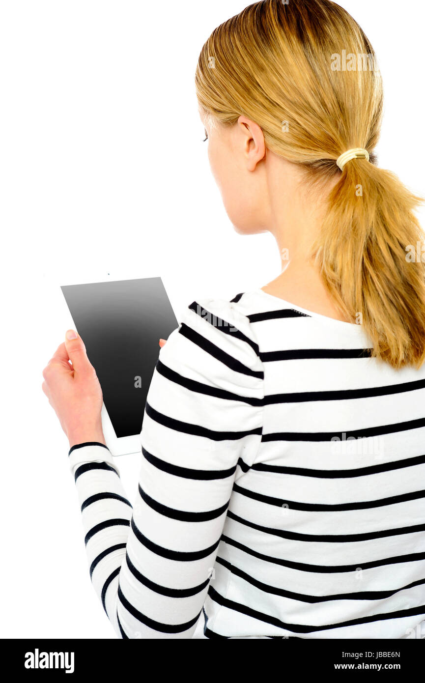Rear view of teenage girl using touch screen device isolated over white ...