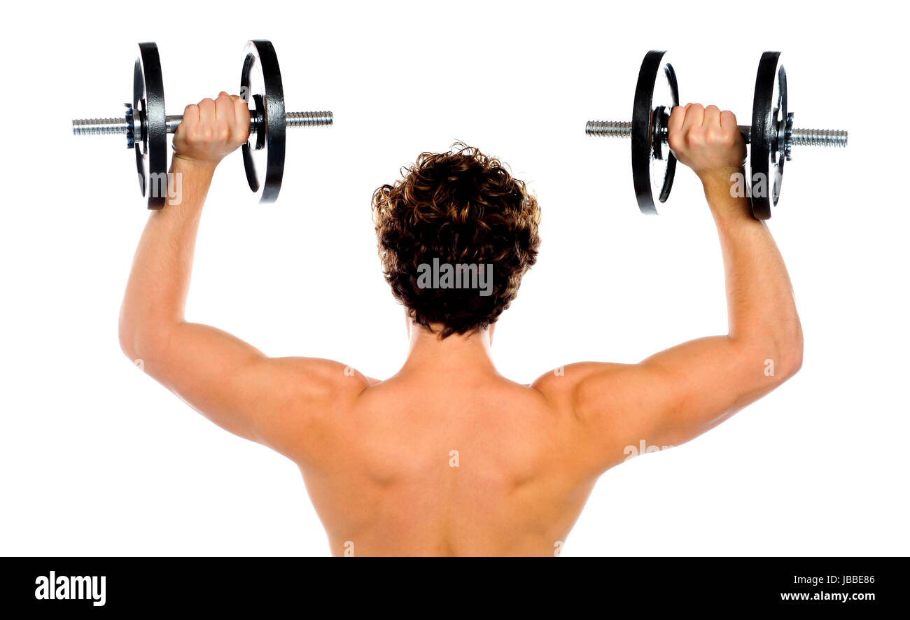 Rear view of a young male bodybuilder doing heavy weight exercise with ...