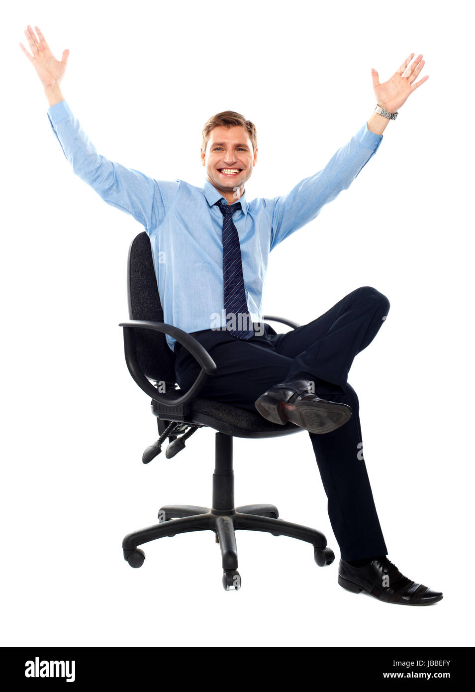 Successful businessman sitting on chair and posing with arms up Stock ...