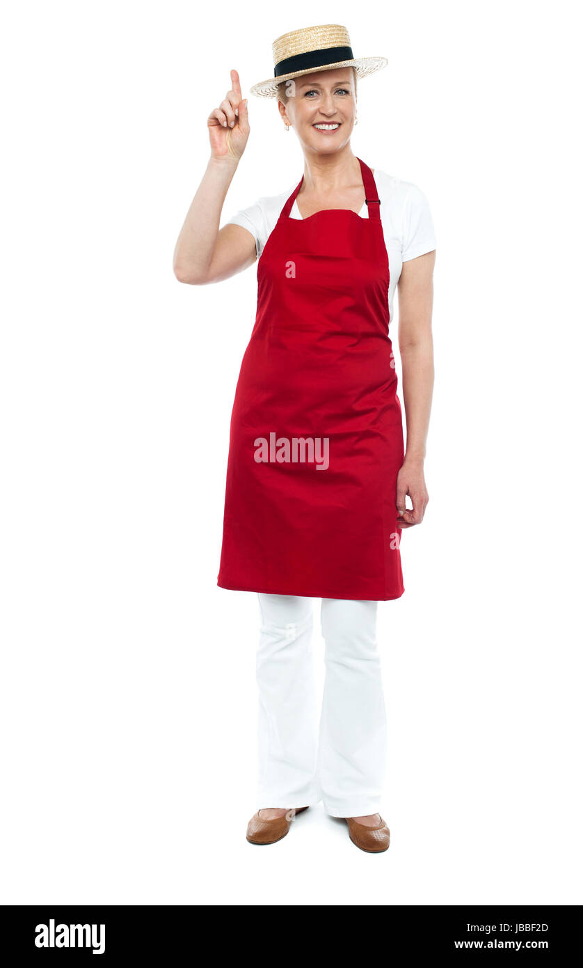 Female chef wearing hat pointing upwards, full length portrait Stock ...