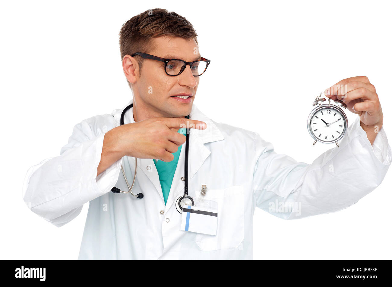 Shocking young doctor pointing at alarm clock isolated over white ...