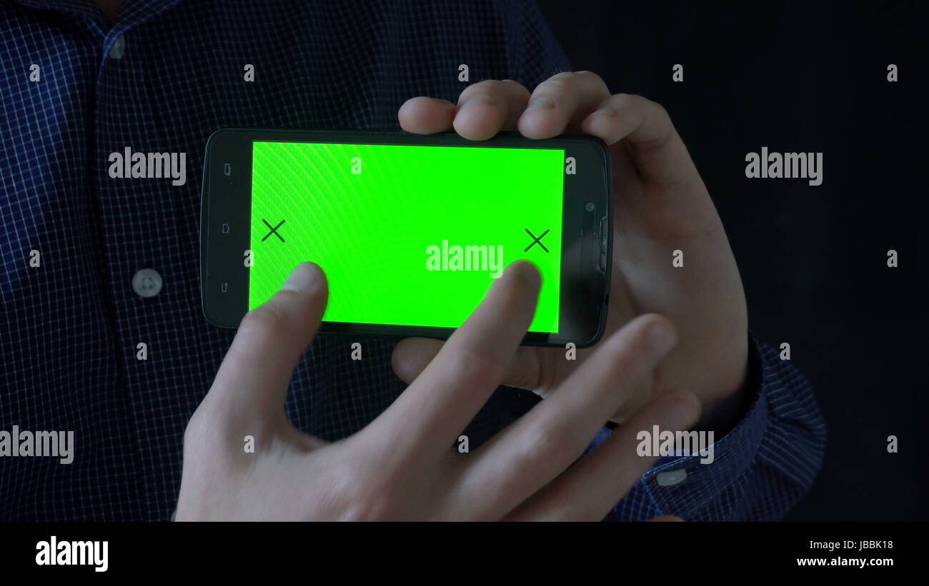 Close-up of male hands touching of smartphone. Green screen Chroma Key ...