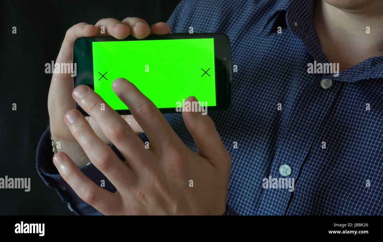 Close-up of male hands touching of smartphone. Green screen Chroma Key ...