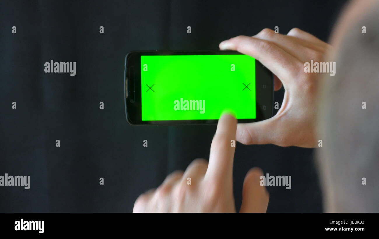 Close-up of male hands touching of smartphone. Green screen Chroma Key ...