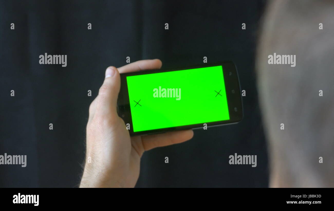 Close-up of male hands touching of smartphone. Green screen Chroma Key ...