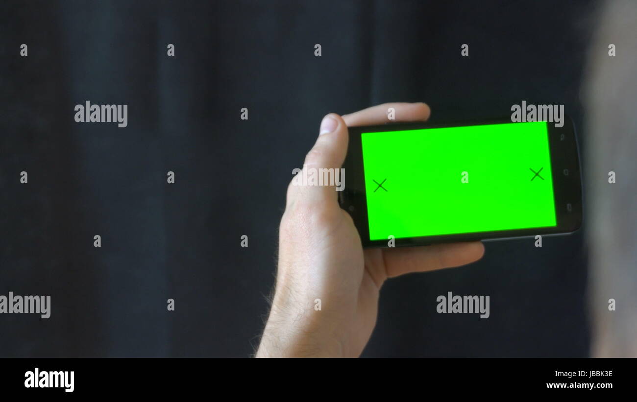 Close-up of male hands touching of smartphone. Green screen Chroma Key ...