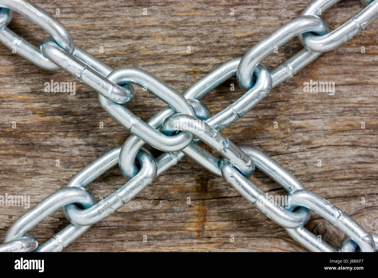 Steel chains crossed on the wooden background Stock Photo - Alamy
