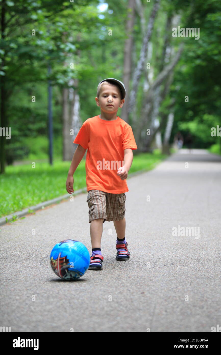 Child running ball road hi-res stock photography and images - Alamy