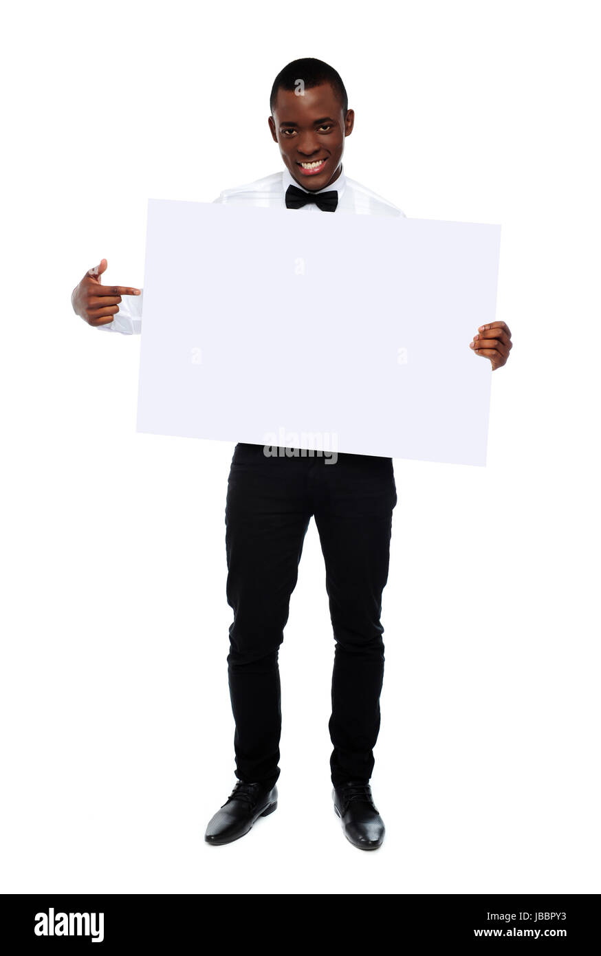 Full length shot of smiling young guy indicating towards blank ...