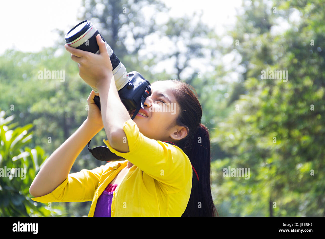1 Indian Girl Taking Picture Using Digital Camera In Park Aiming ...
