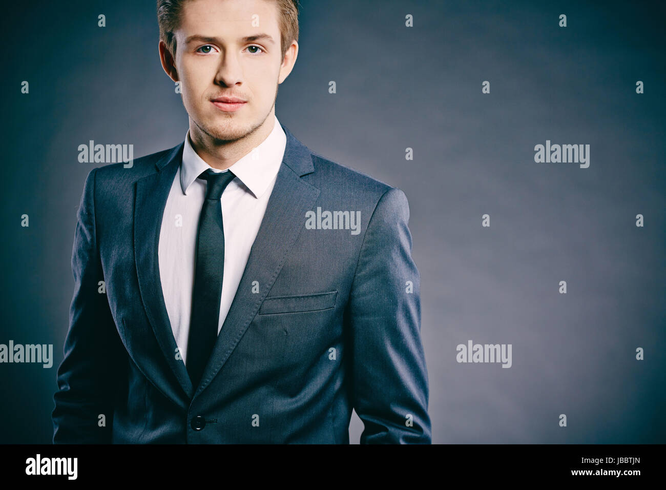 Portrait of a young businessman looking at camera in isolation Stock ...